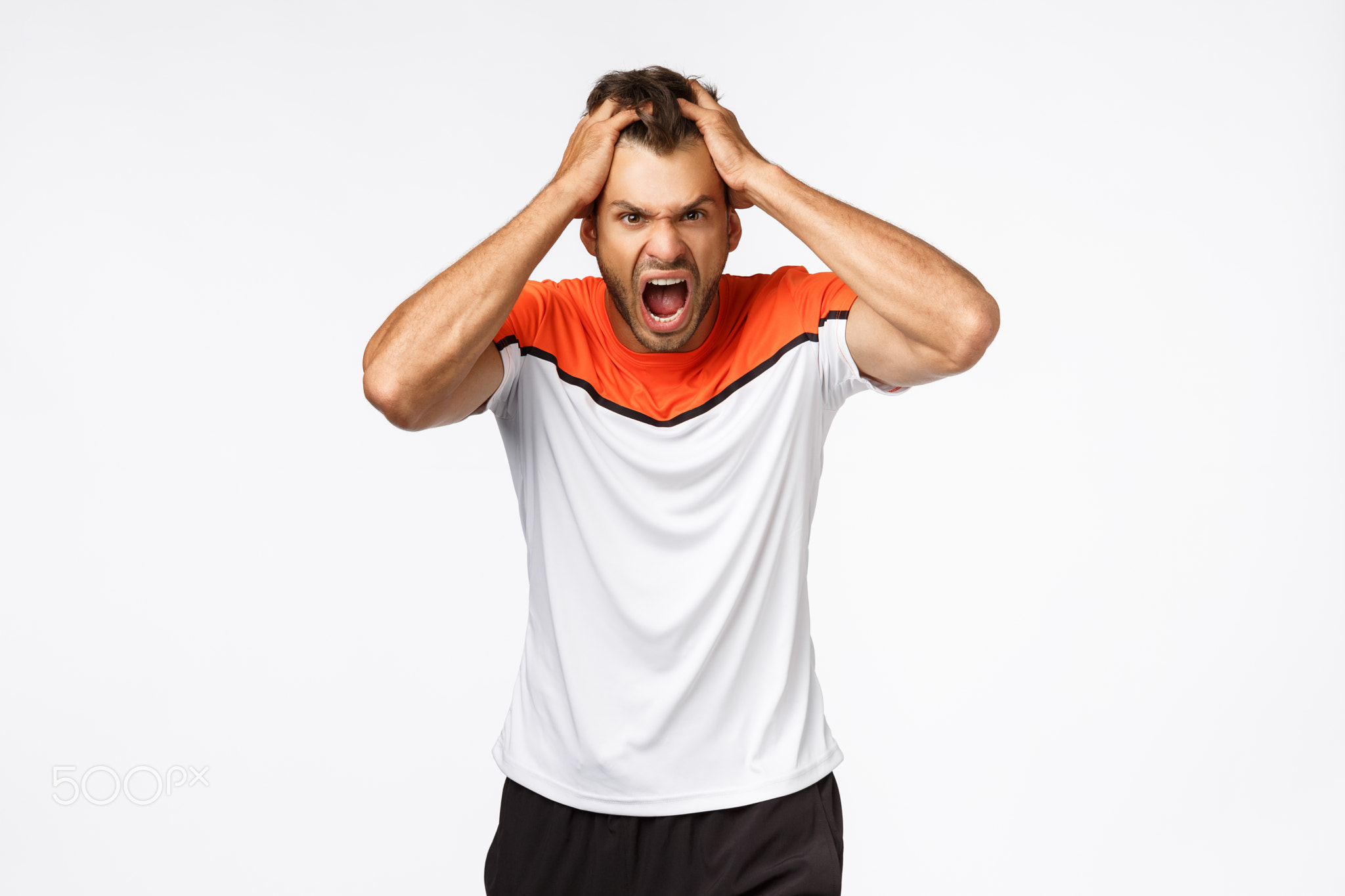 Angry, aggressive mascular sportsman looking furious, grab head in rage ...