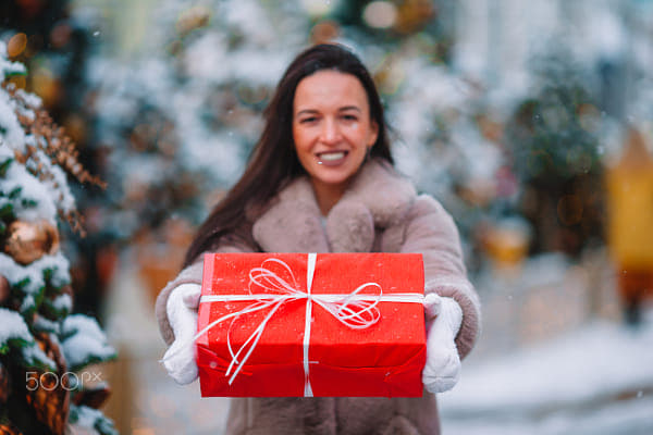 Happy girl near fir-tree branch in snow for new year. by Dmitrii ...