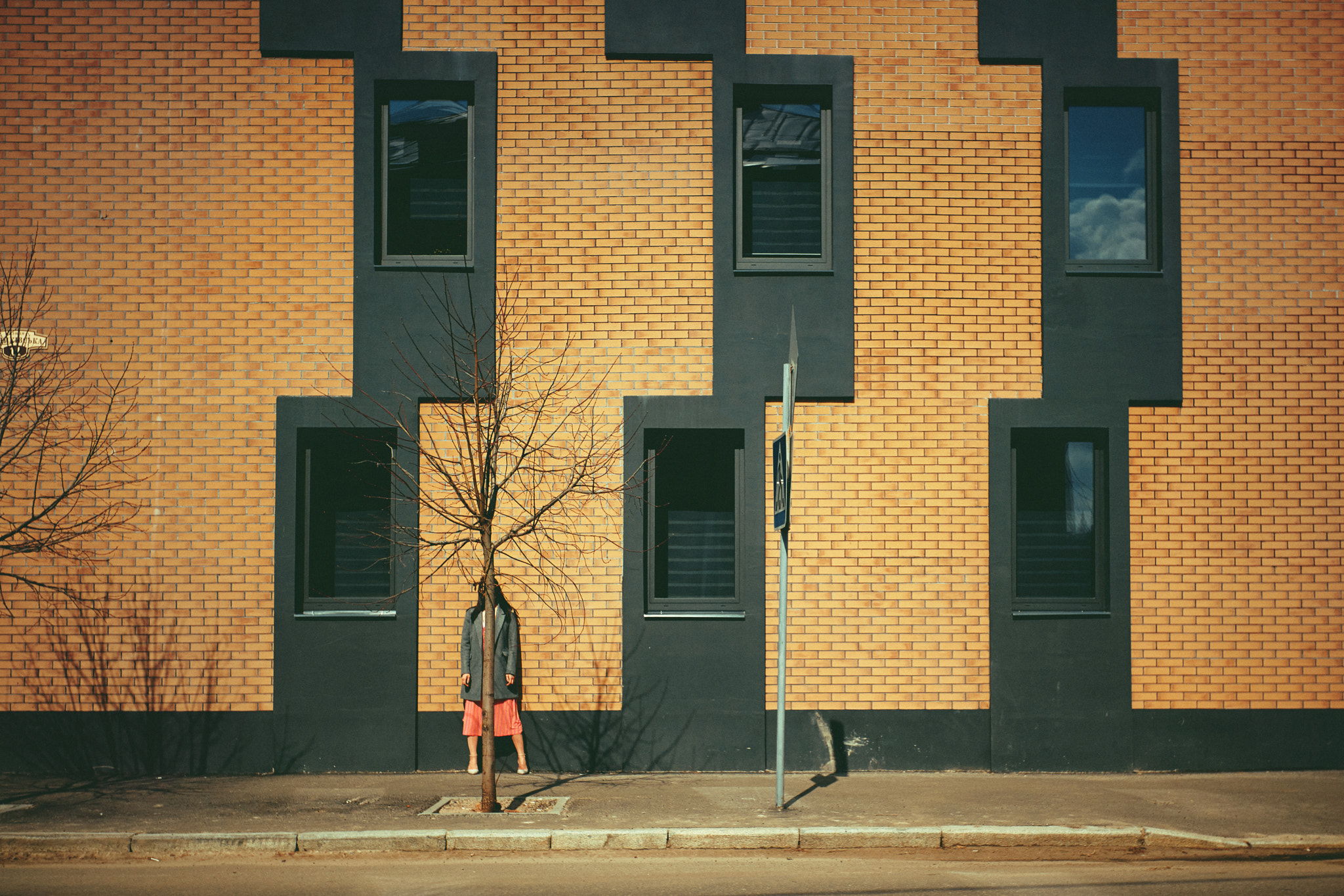 Woman Walking Past Modern Brick Building | people photo by Anastasiia ...