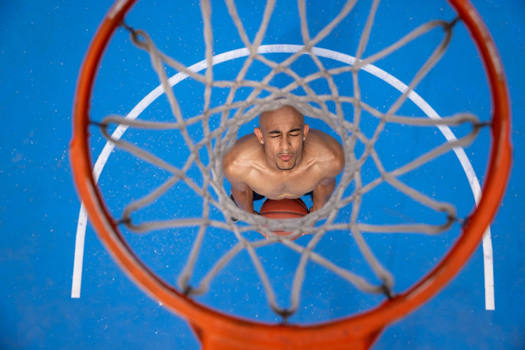 Top view through basketball hoop. Young man basketball player at by ...