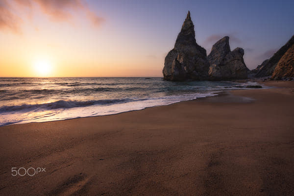 Ursa Beach, Sintra, Portugal. Sand beach with rocks silhouette in by ...