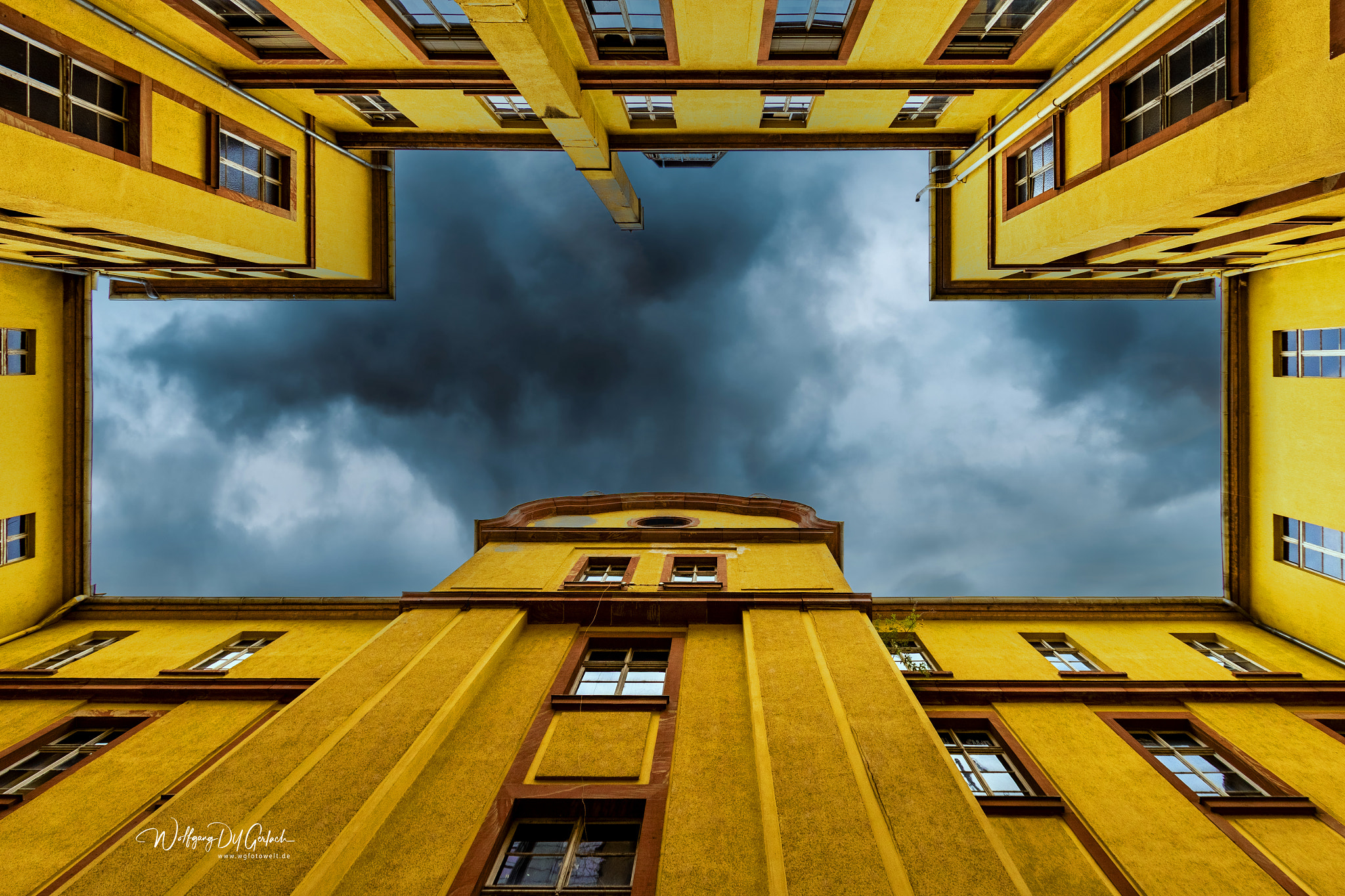 Yellow Building Courtyard with Dramatic Sky | city photo by Wolfgang DY ...