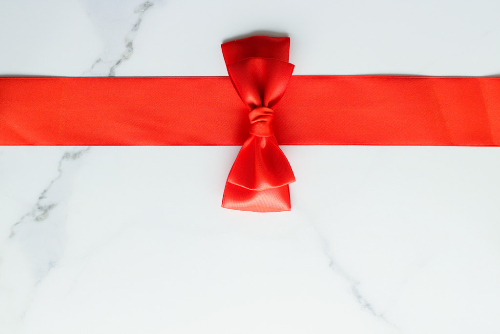 Red silk ribbon on marble, top view by anneleven / 500px