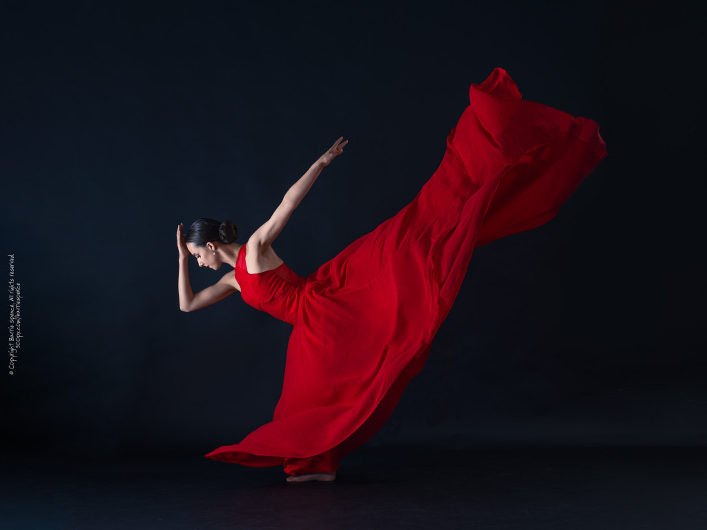 Full length of woman dancing against black background by Barrie Spence ...