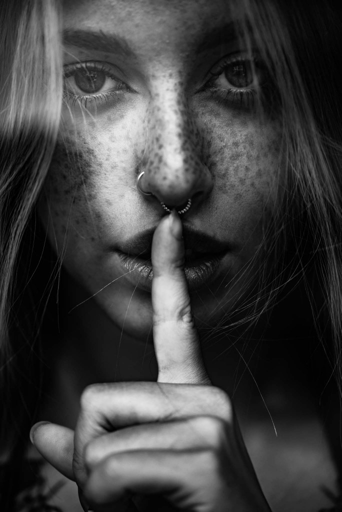 Close-up portrait of young woman with finger on lips by Pier sparello ...