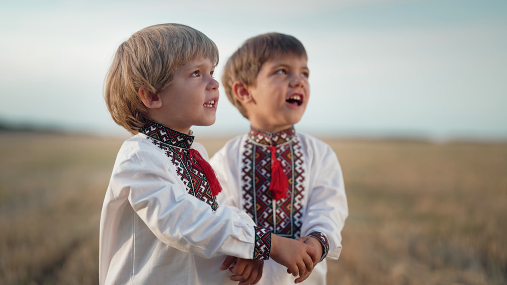 Beautiful portrait of little ukrainian boys singing song in wheat by ...