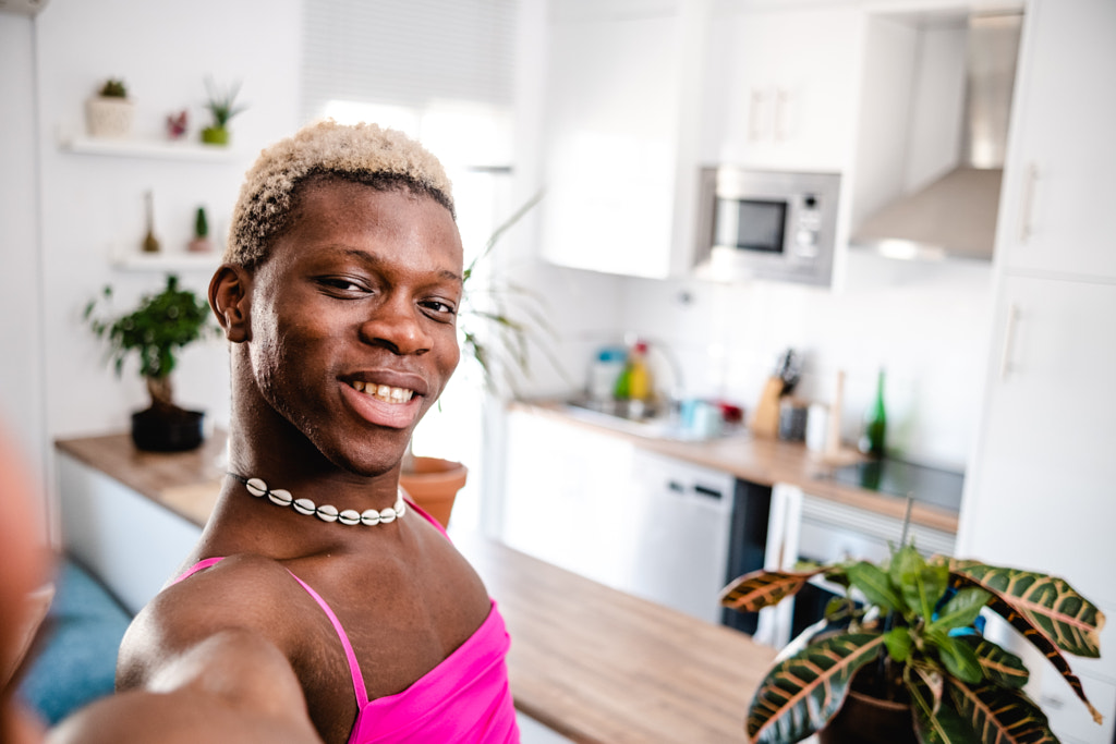 Happy black transsexual man taking selfie in modern apartment at by ...
