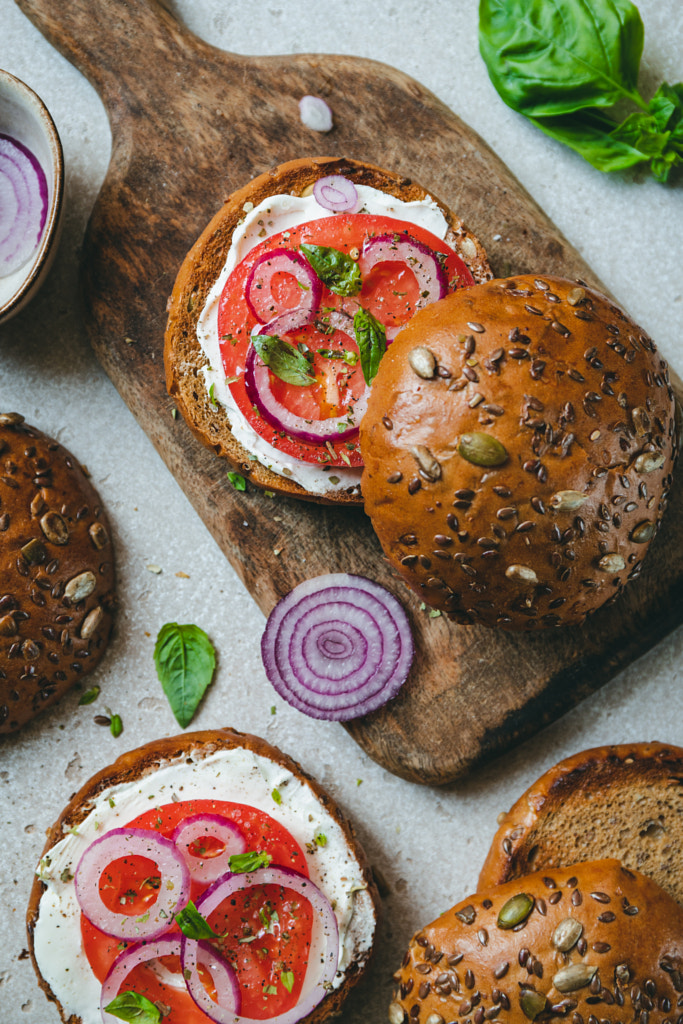 Top view of rye bread rusted buns with cream cheese, fresh tomato ...