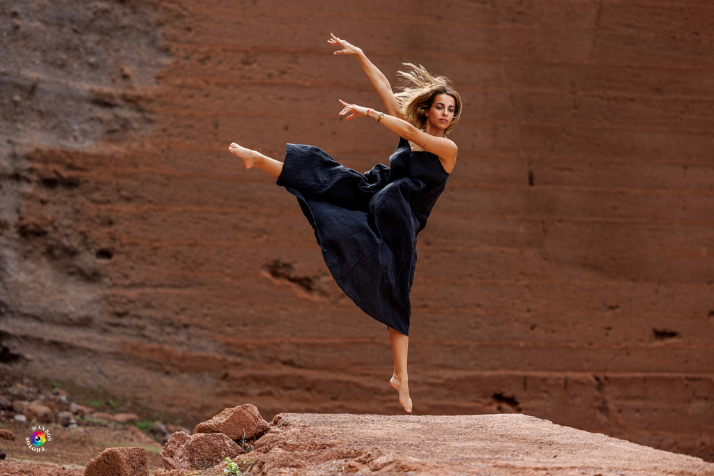 Full length of woman dancing on rock against wall by Manbos Garcia / 500px