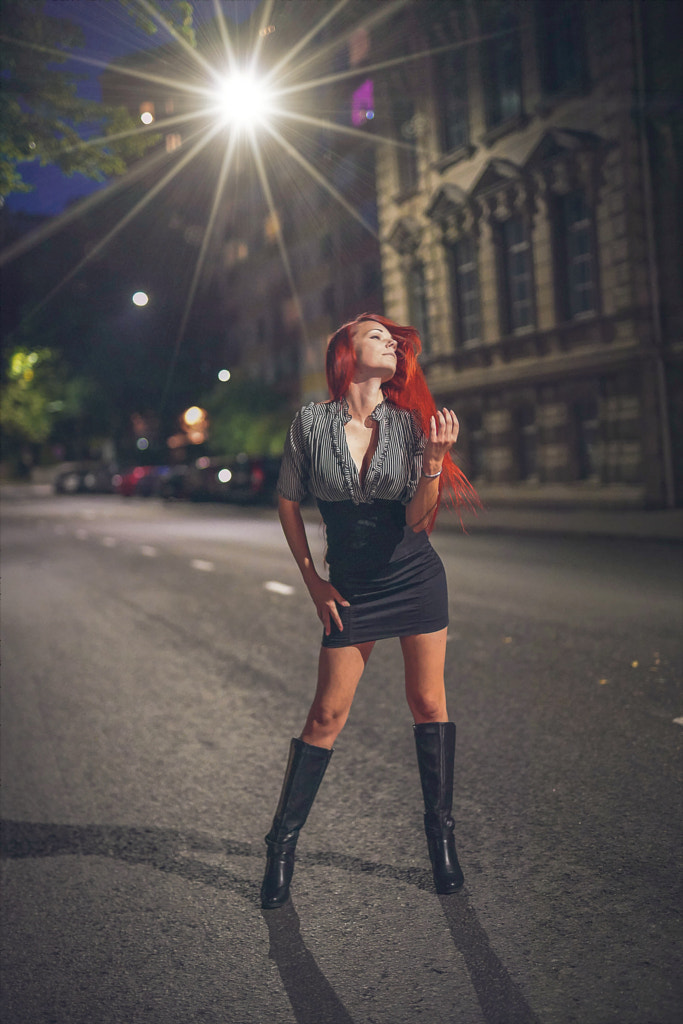 Young woman dancing on street in city at night by Petri Naukkarinen / 500px