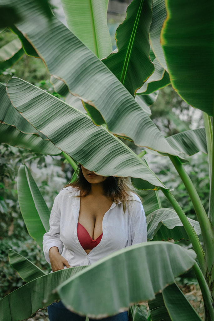 women's cleavage behind banana leaves by FIRDaus Daus / 500px