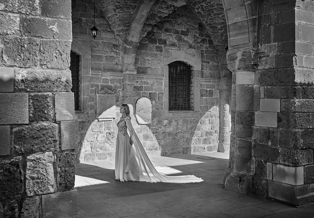 Woman standing against historic building by David Solodar / 500px