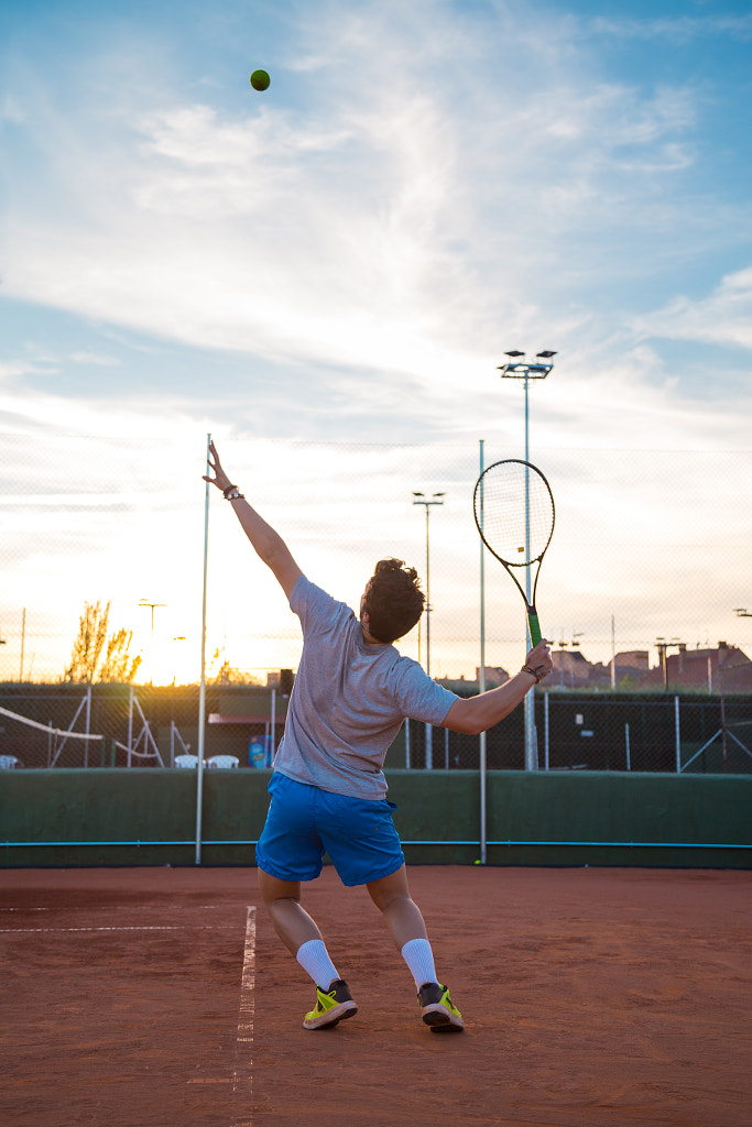 Professional tennis player throwing ball in the air before hitting it ...