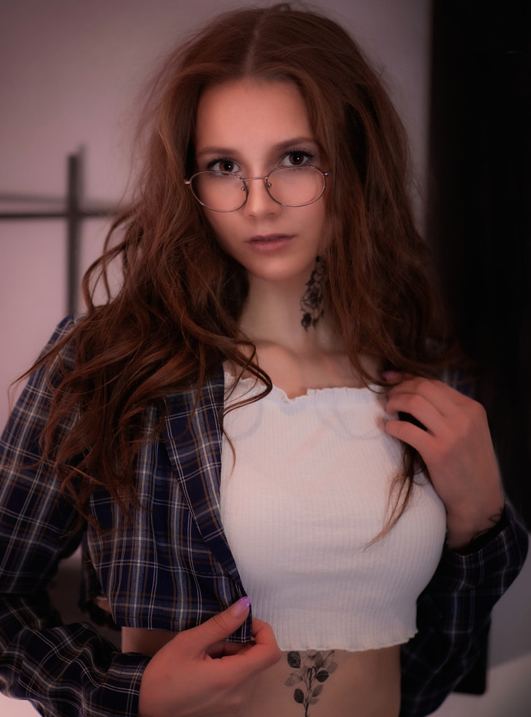 Portrait of young woman standing at home by Frank Reinbold / 500px