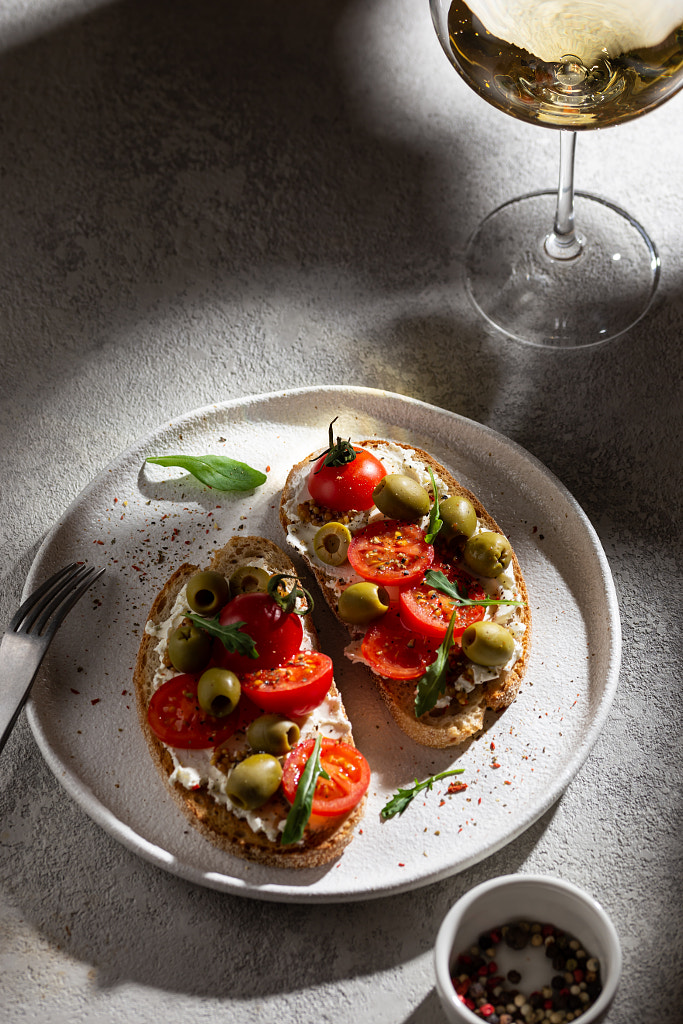 Plate with bruschettas and glass of wine by tmedvedtskaya / 500px