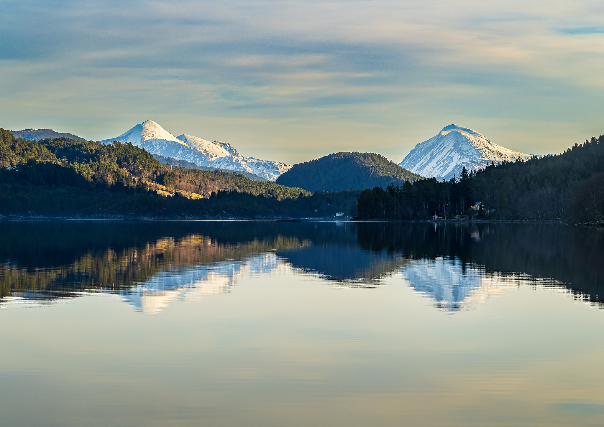 Scenic view of lake by snowcapped mountains against sky by Torstein Holm / 500px