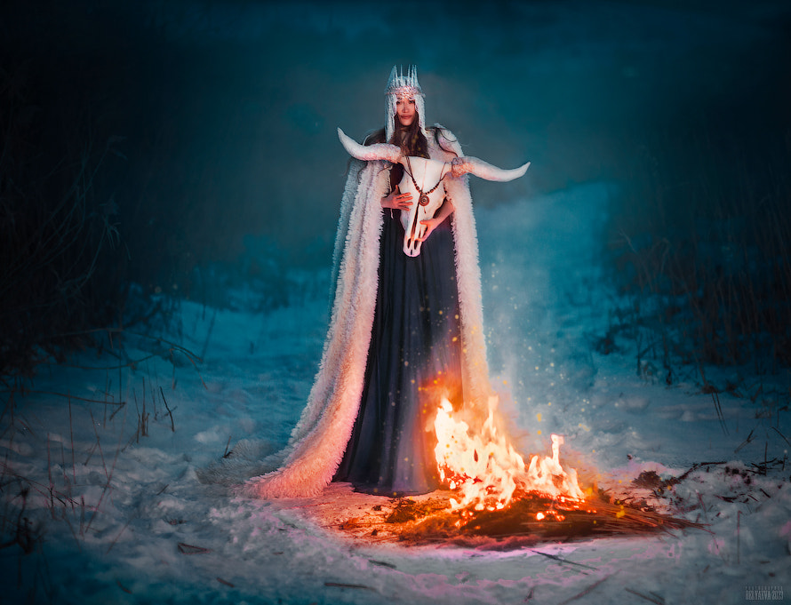 Woman wearing costume while standing by bonfire at night by Светлана ...