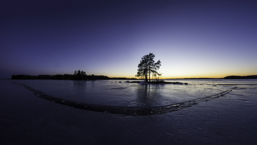 Scenic view of frozen lake against clear sky at sunset by Kari Siren ...