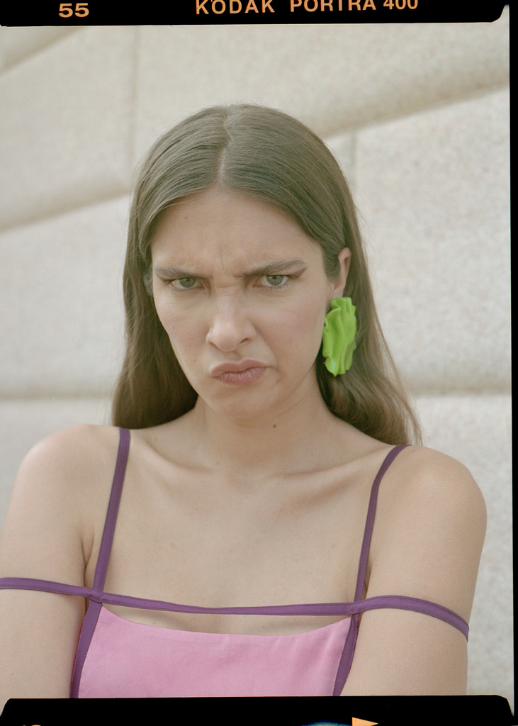 Portrait of young woman against wall (analog shot) by Carlotta Ricci ...