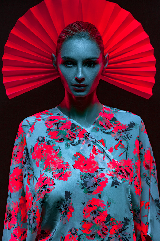 Portrait of young woman with make-up against black background by ...