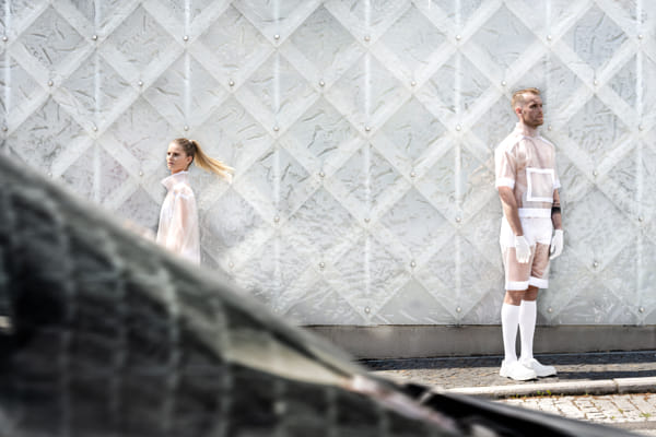 Two People in White Outfits Against a Textured Wall | people photo by ...