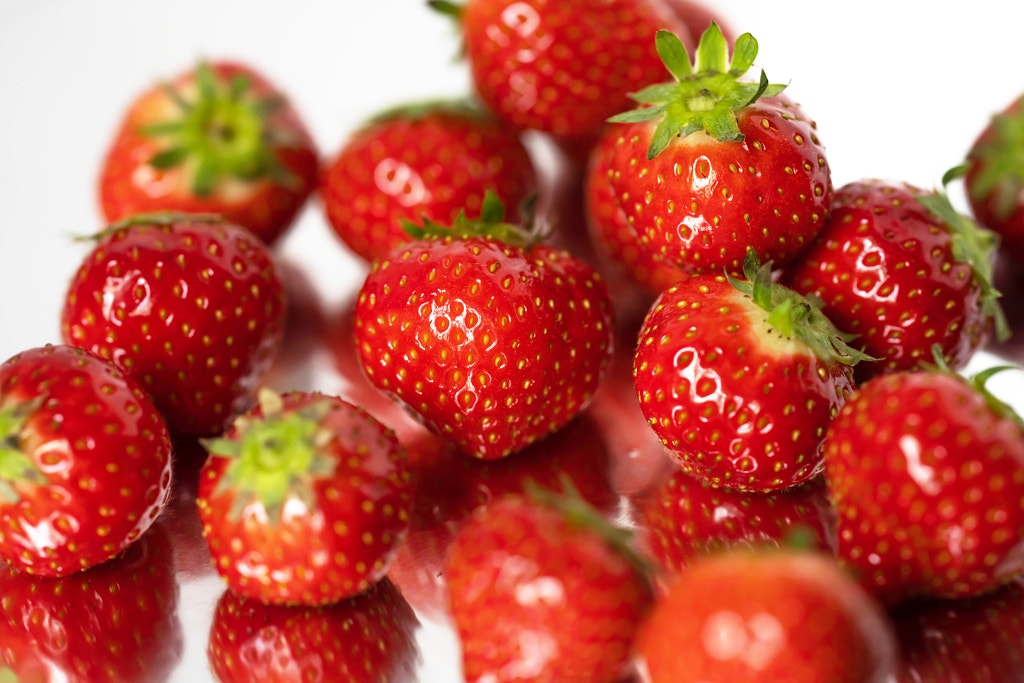 juicy ripe strawberries with green leaves by Olga Gvozdeva / 500px