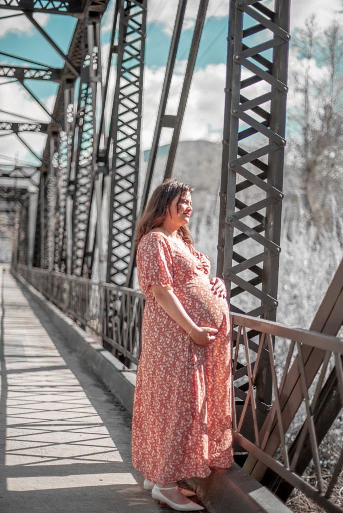 Side view of pregnant woman standing on footbridge by sayph / 500px