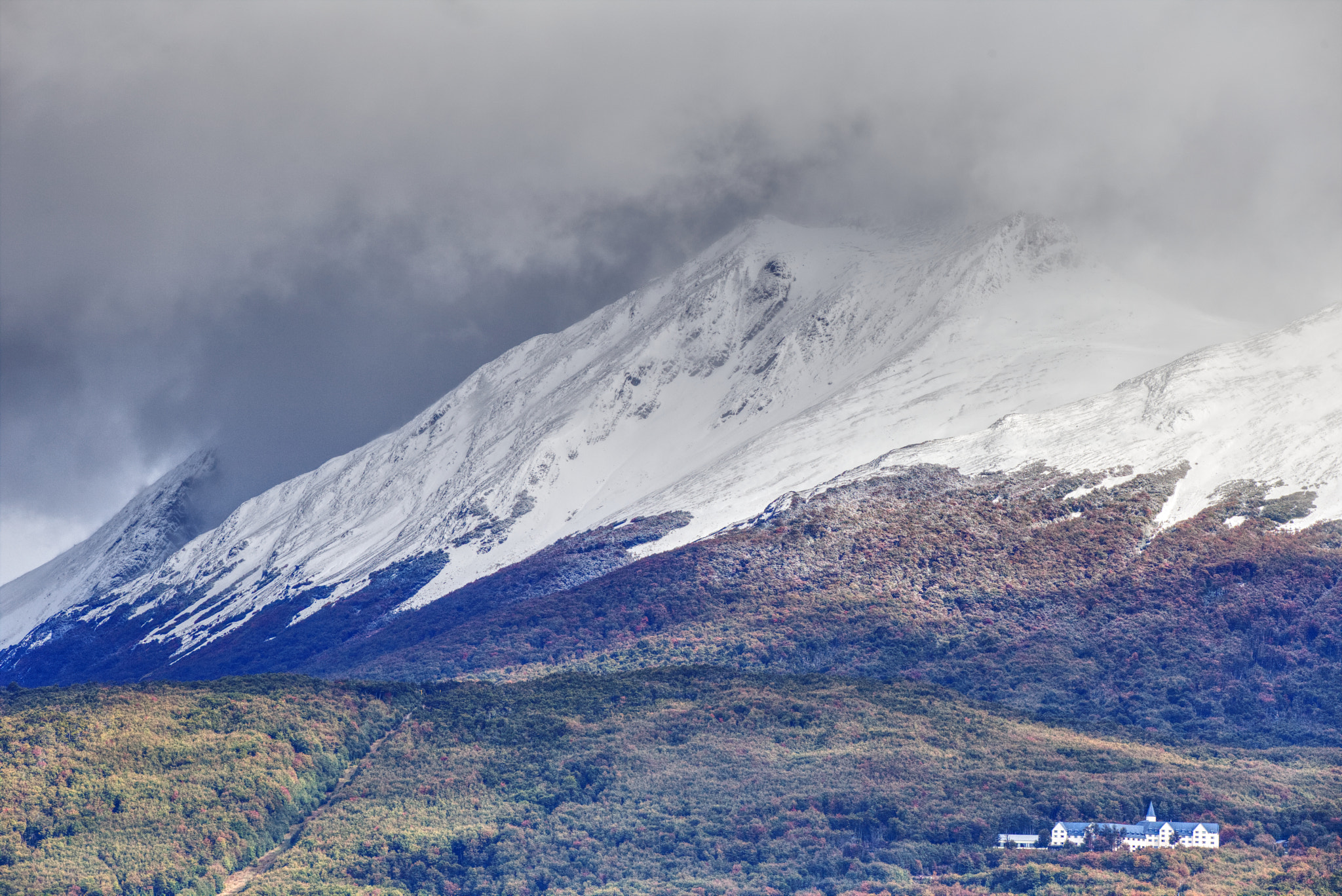 Dark clouds move over snow-capped mountain peaks by Bernd Dembkowski ...