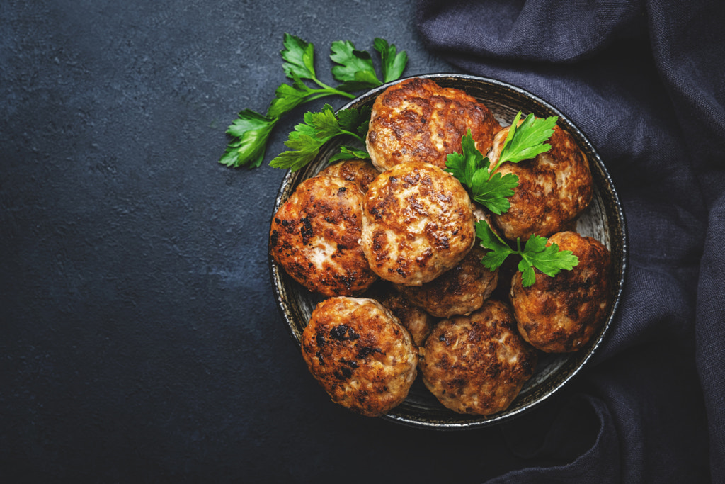 Homemade fried pork and beef meatballs in bowl, dark table background ...