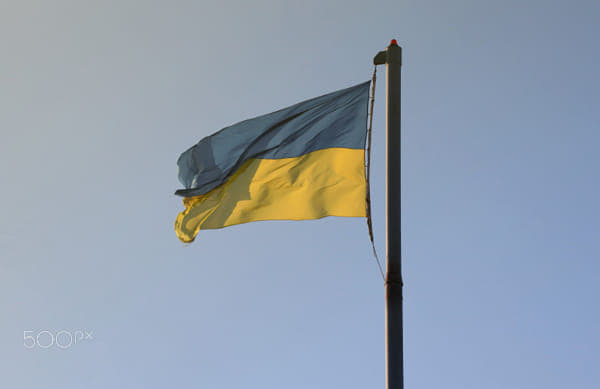 Ukraine flag large national symbol fluttering in blue sky. Large yellow ...