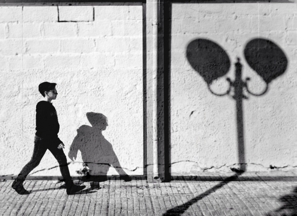Man Walking Past Streetlight Shadow on Wall | city photo by Charalampos ...