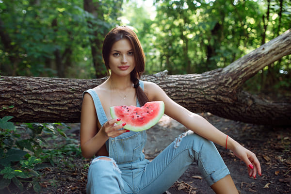 Picnic in nature and healthy eating. A sexy girl in the woods eats ...