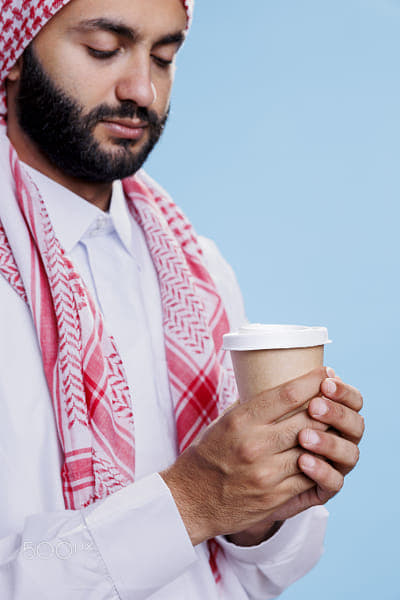 Arab man holding coffee to go paper mug by Dragos Condrea | 500px