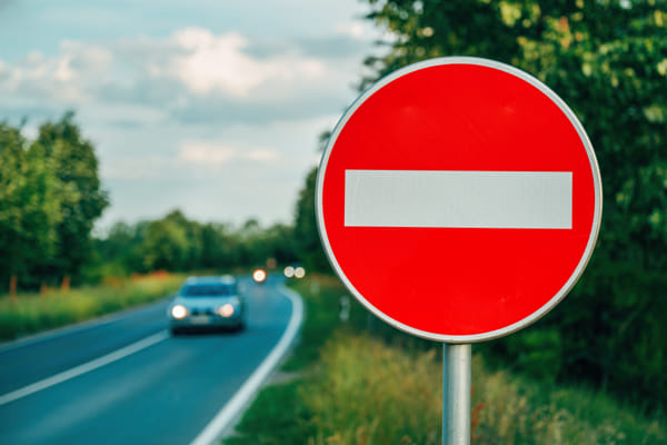 No Entry traffic sign by the european road with cars driving along the ...