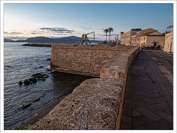 Ancient Stone Wall Along Coastal Town at Sunset | city photo by ...