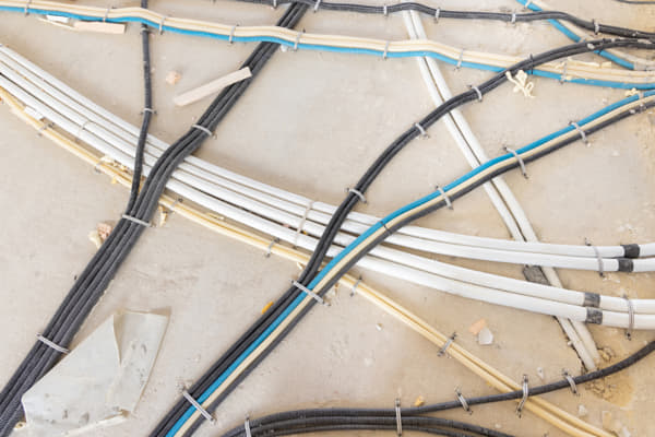 Electricity tubing is laid across the floor of an unfinished room ...