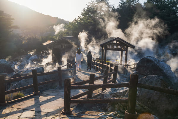Tourist female friends at Hell valley Jigoku in Mount Unzen at sunset ...