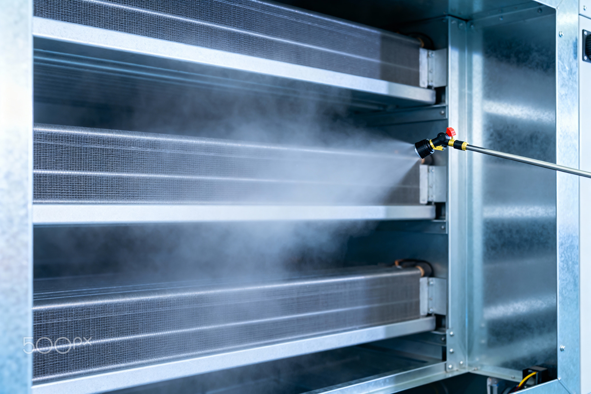 Industrial air conditioning unit being cleaned with a spray nozzle by ...