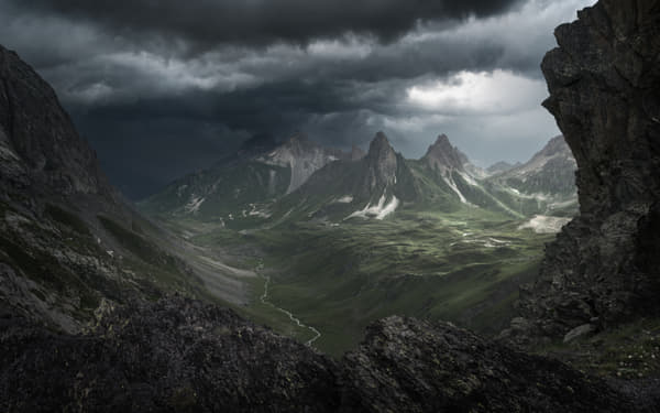 Dramatic Mountain Valley Under Stormy Skies Evoking Awe and Raw Power ...