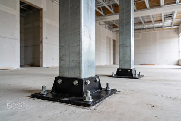Steel support columns with bolted base plates in an unfinished building ...