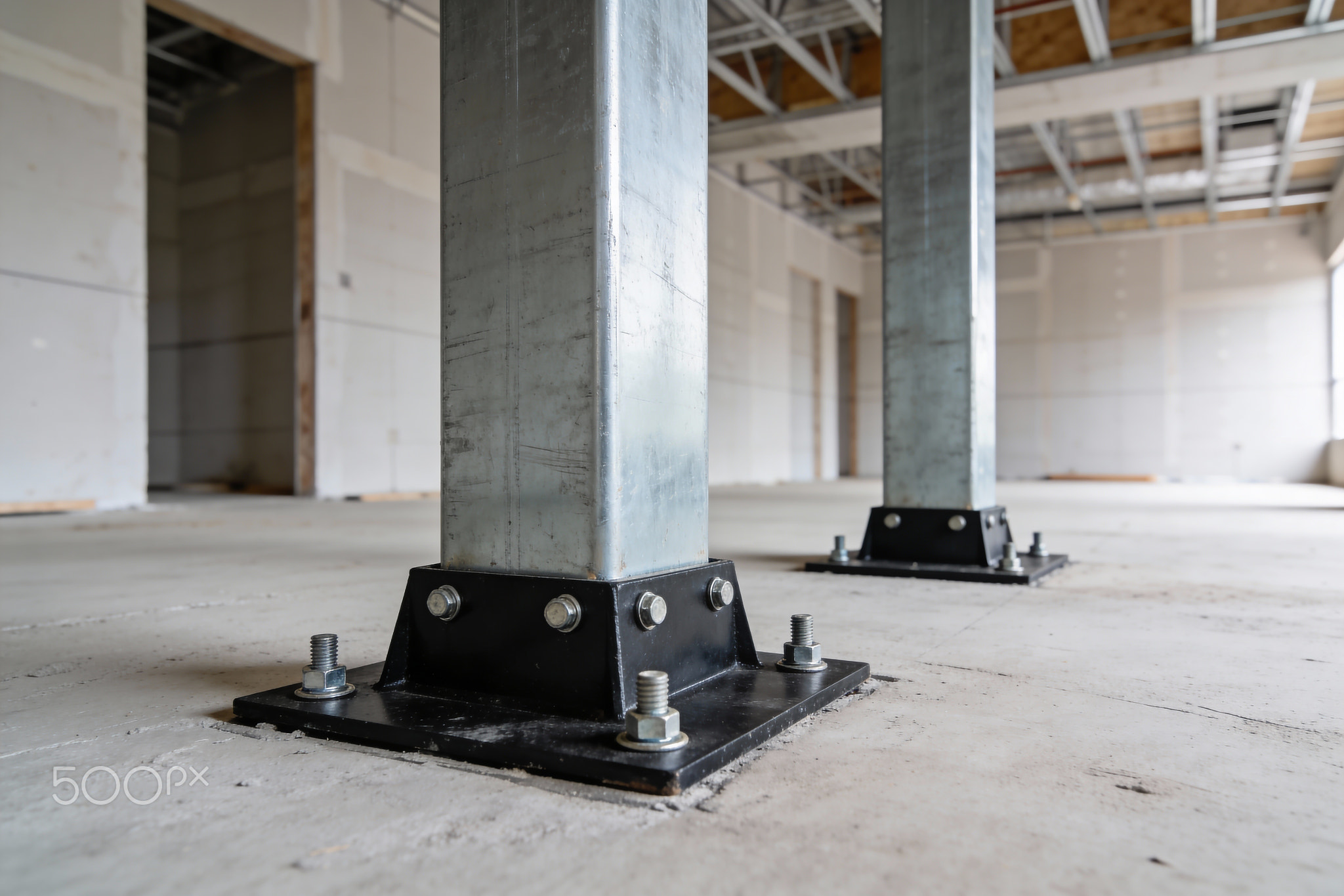 Steel support columns with bolted base plates in an unfinished building ...