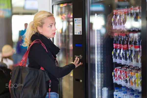 Lady using a modern vending machine by Matej Kastelic / 500px