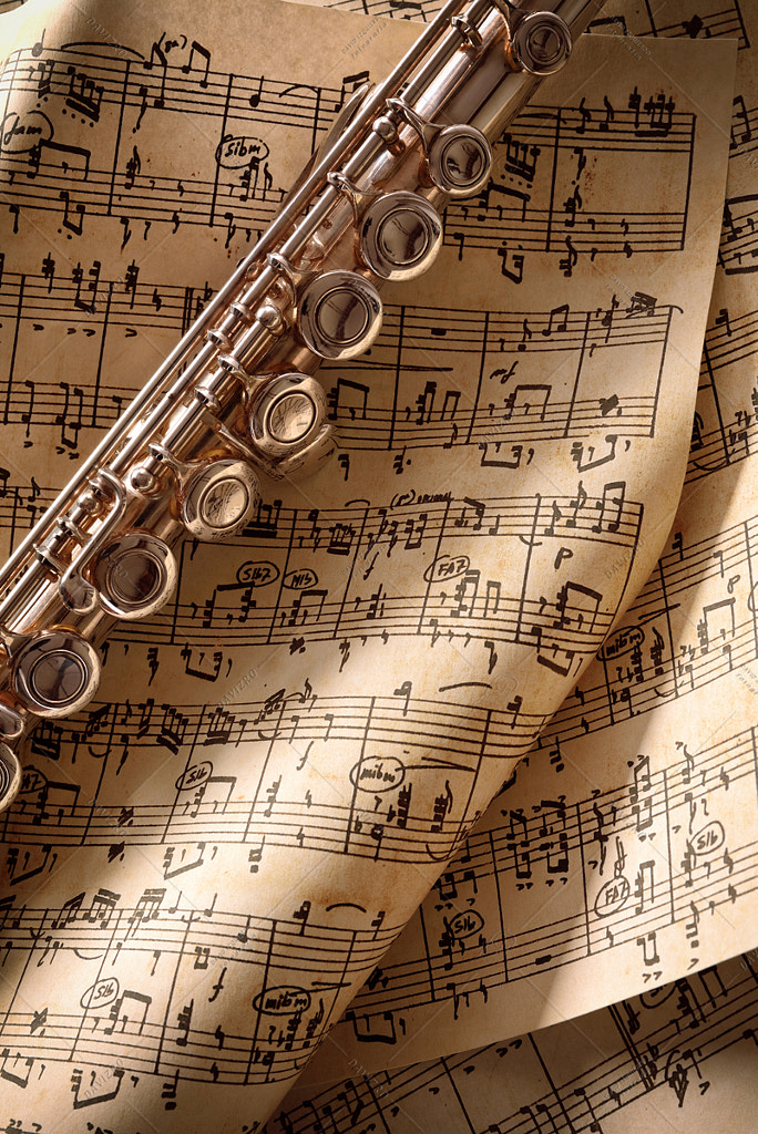 Flute on old handwritten folded sheet music top view vertical by David ...