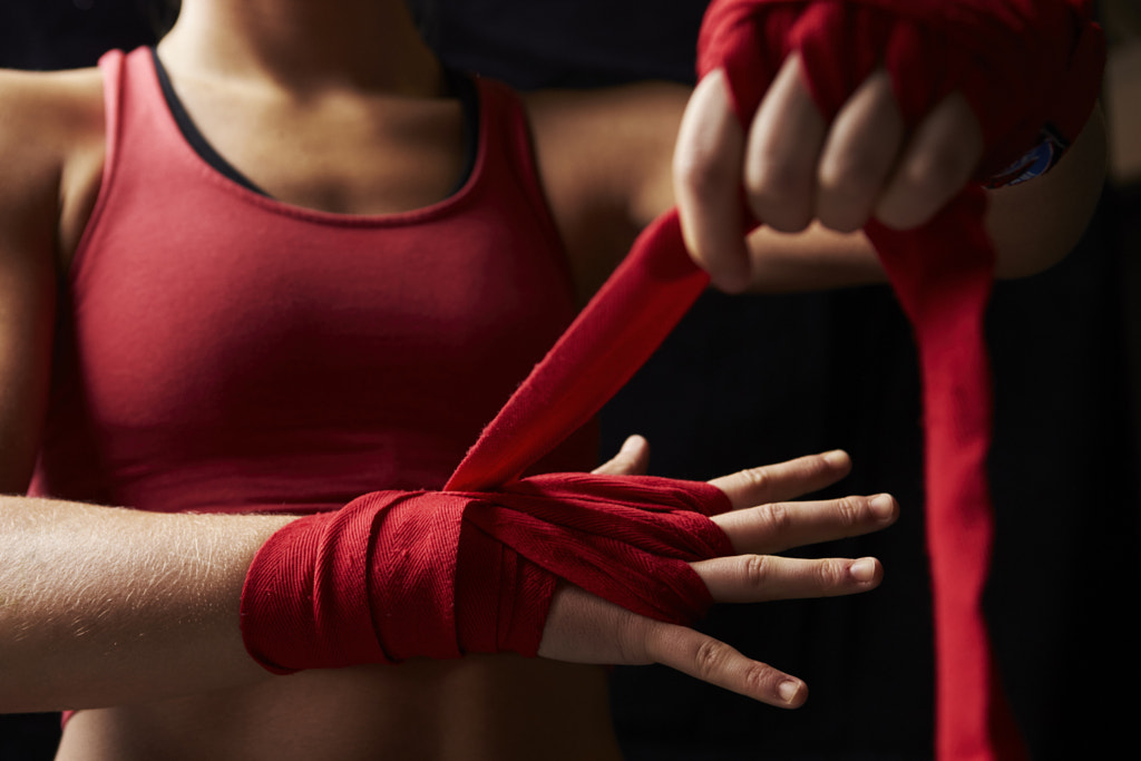 Woman wrapping hand for boxing training, hands to camera by Guerilla ...