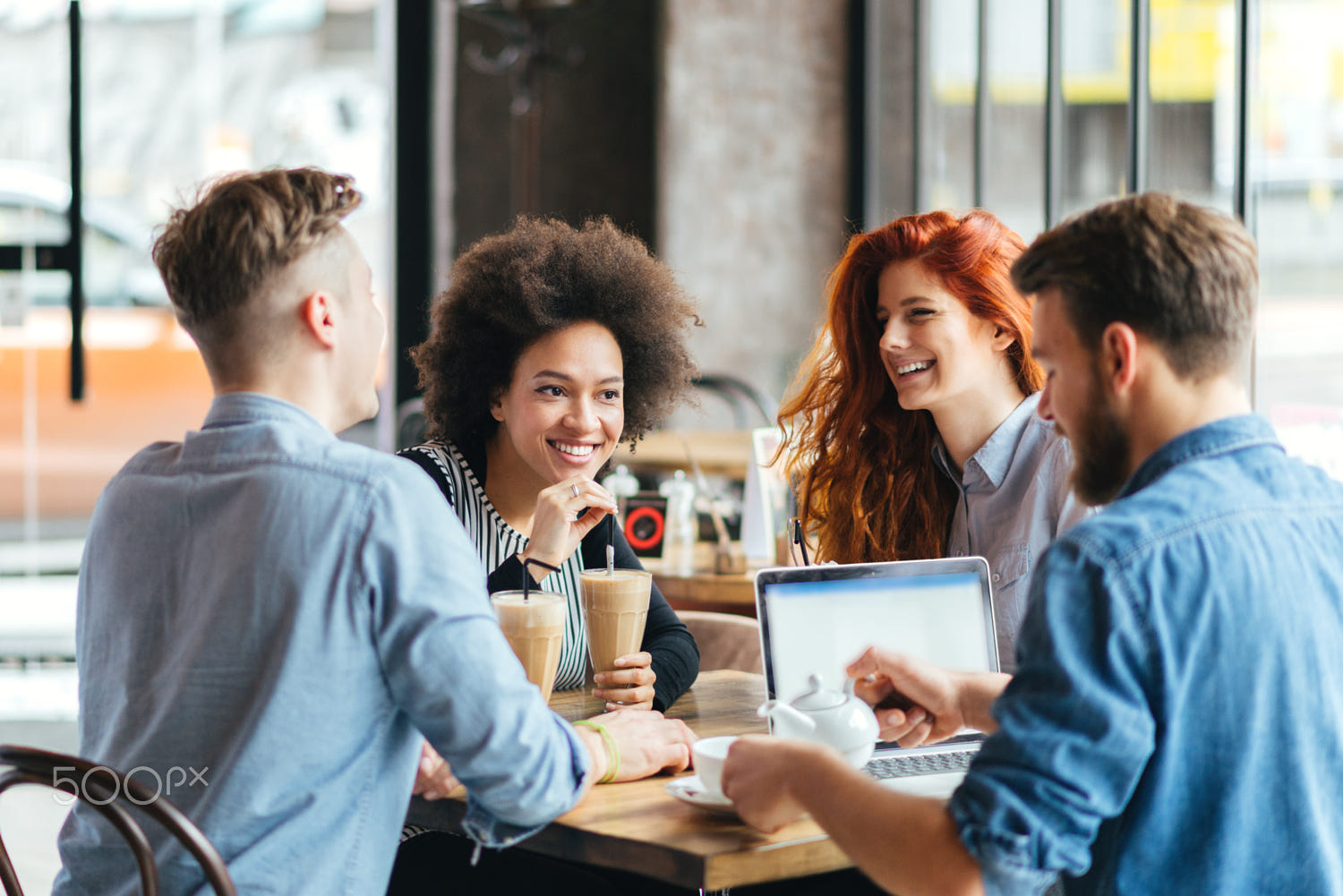 Young smiling people enjoying coffee by Igor Milic / 500px