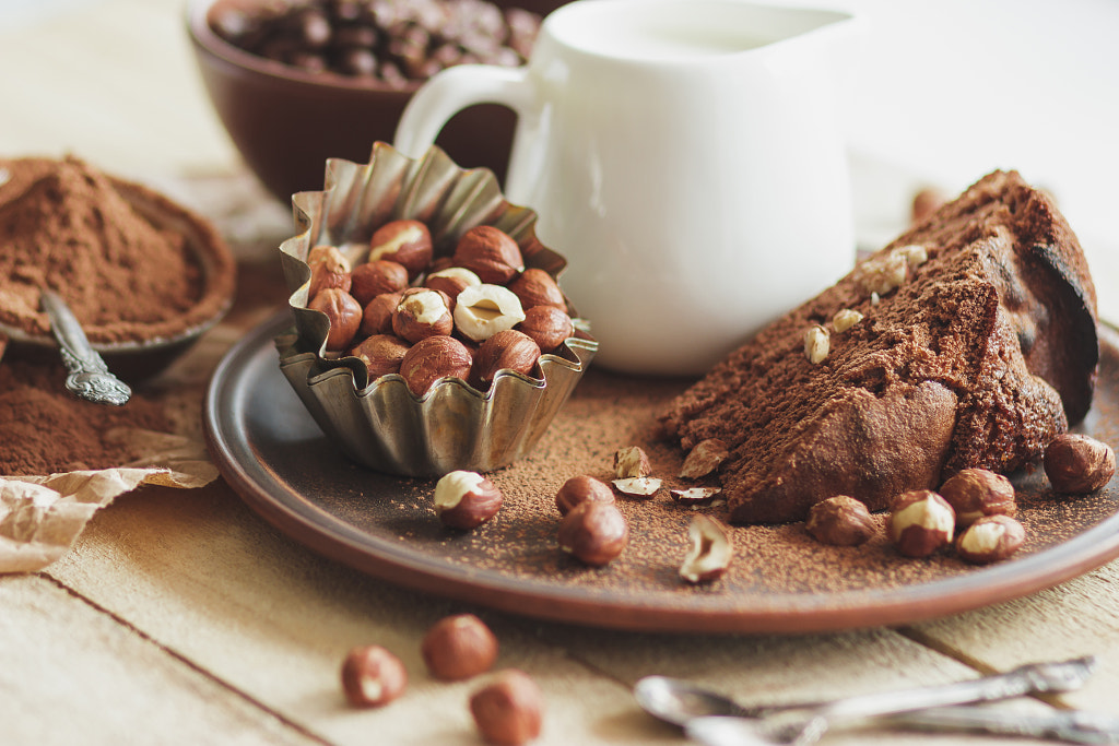 Piece of chocolate cake, hazelnuts and jar with milk by Елизавета Ткач ...