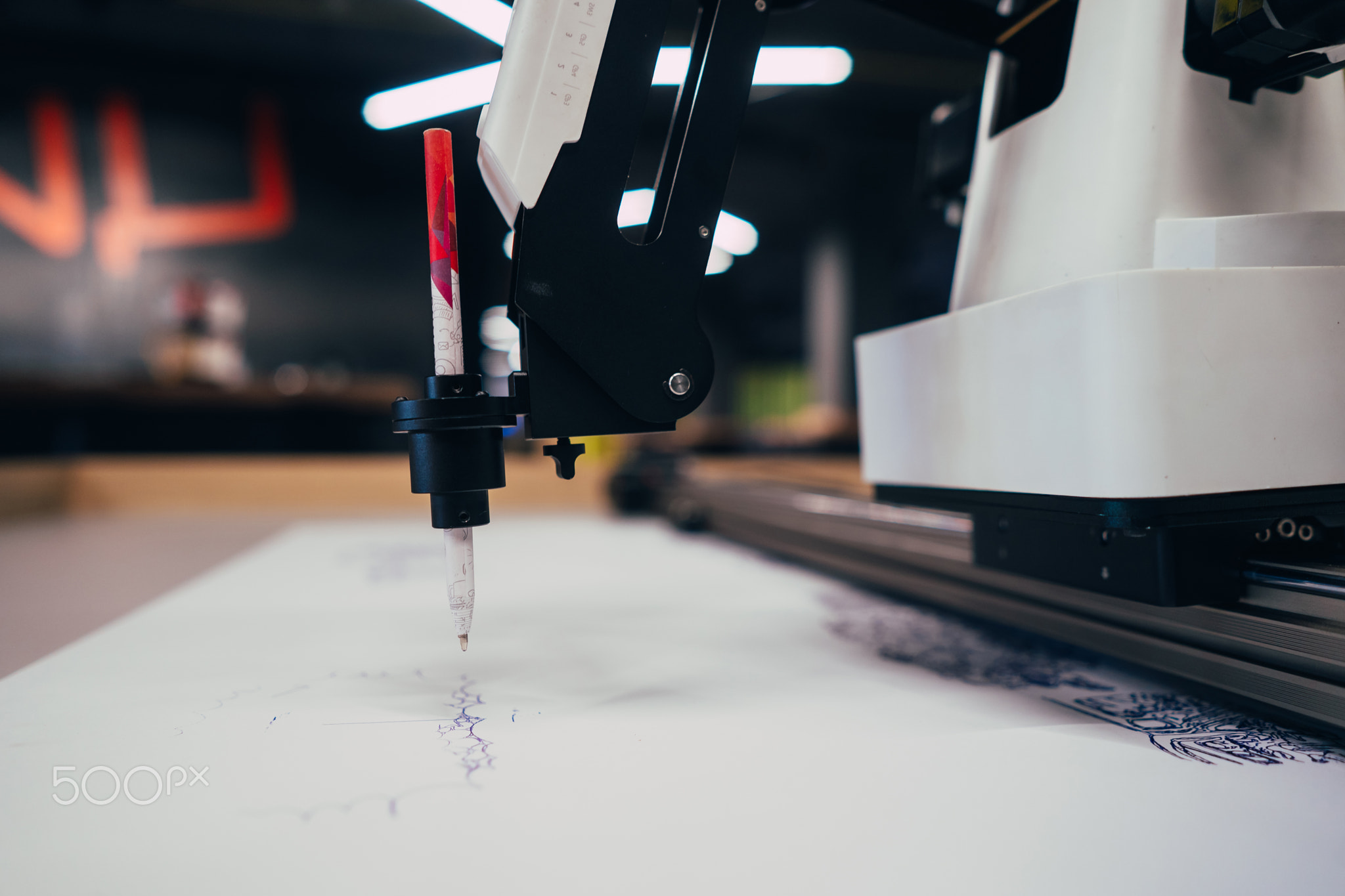 Plotter draws a pen drawing on a sheet of white paper by Oleksii ...