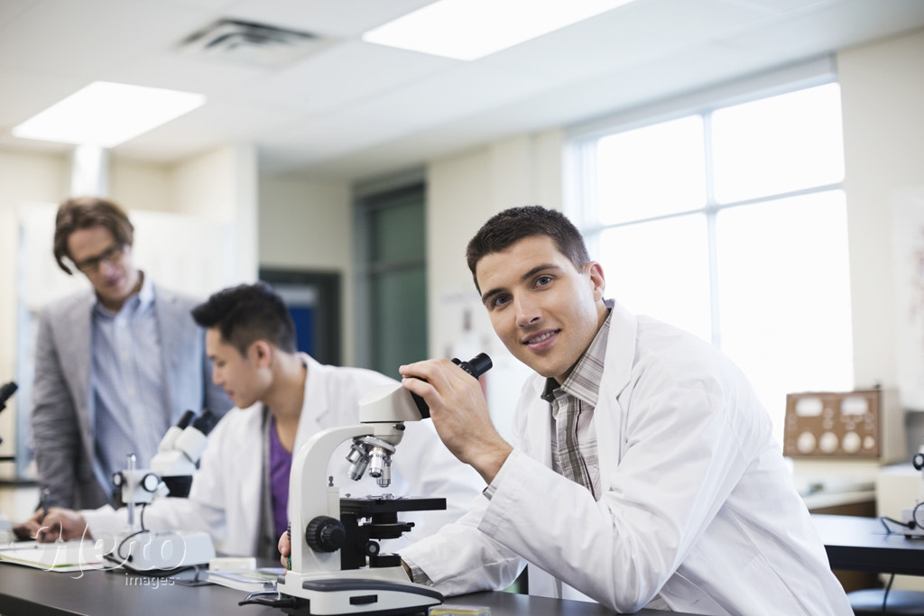 Portrait of male student with microscope in college science lab by Hero ...